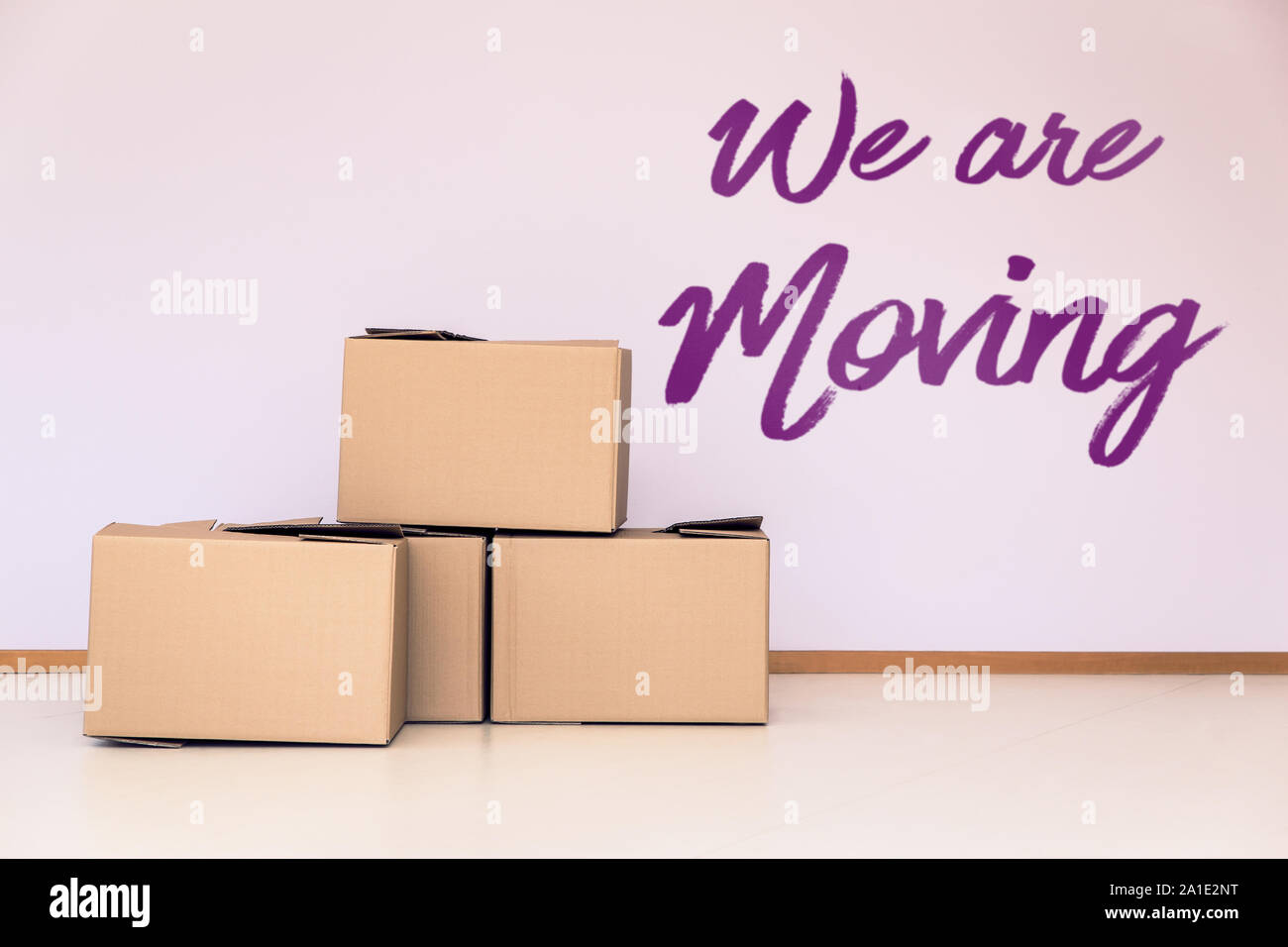 lot of moving boxes in an empty room, text we are moving Stock Photo ...