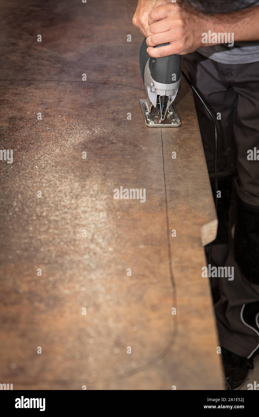 man is working with an electrical jigsaw Stock Photo - Alamy