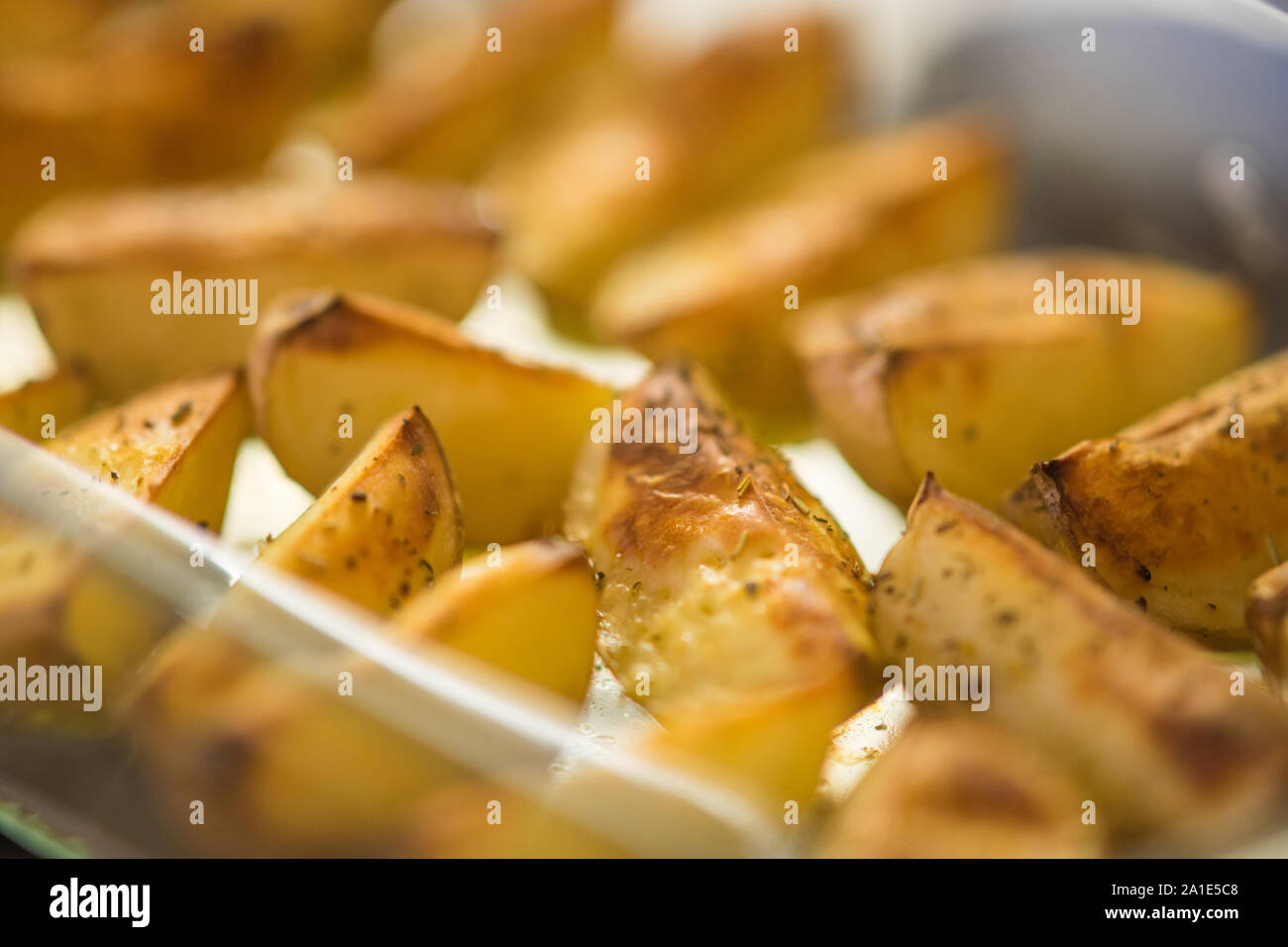 ready baked potato slices with spices lie in glass dish after oven ...
