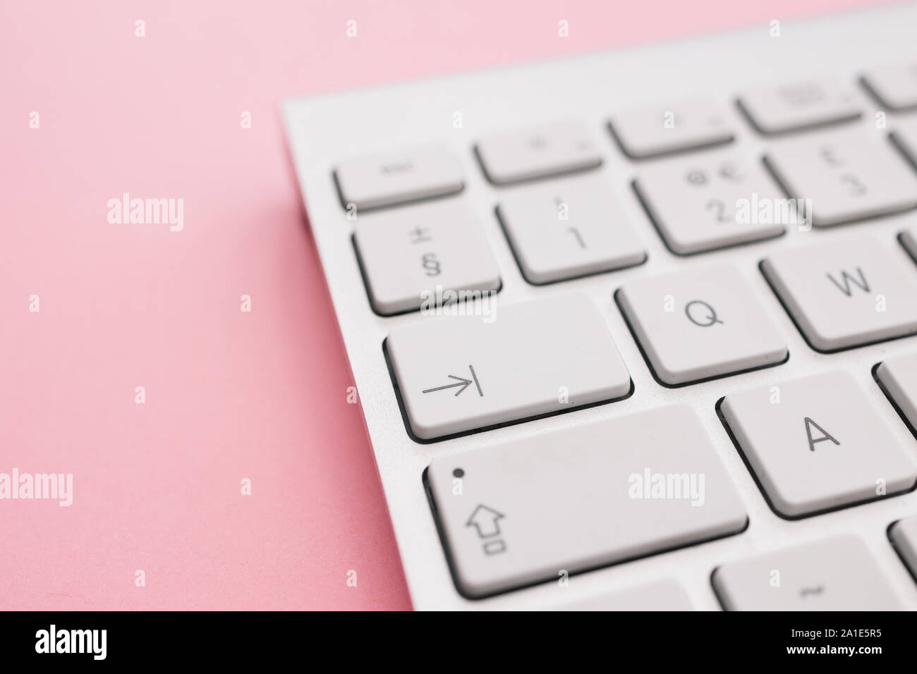 Computer keyboard minimal home office bright pink color background top ...