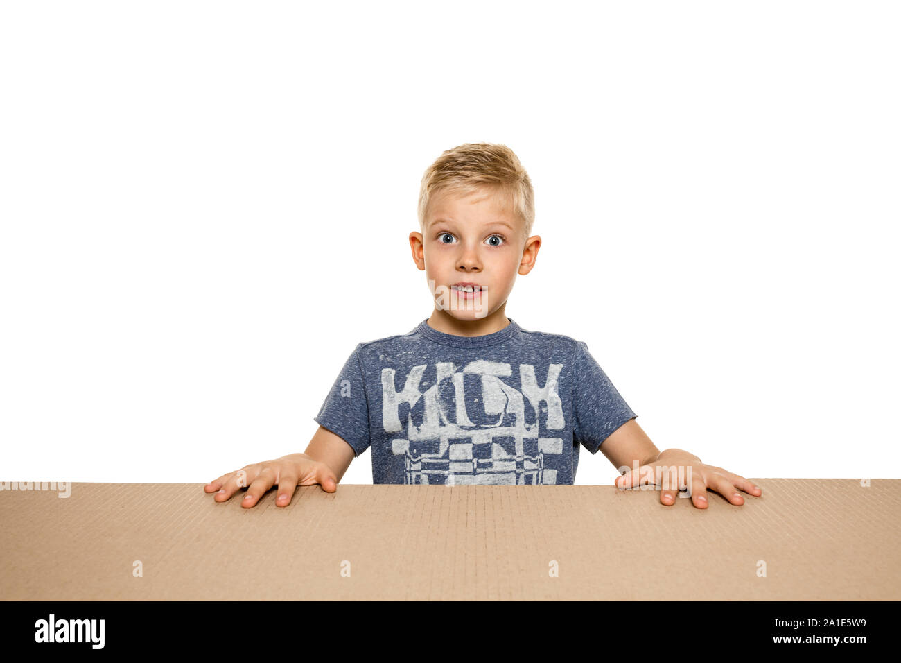 Cute, astonished little boy opening the biggest postal package. Shocked ...