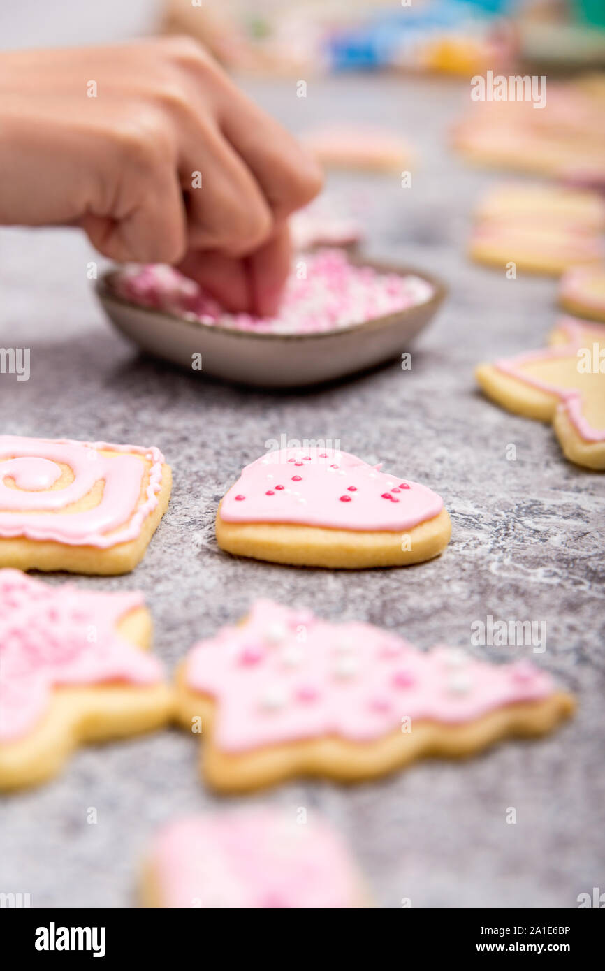 Decoration of delicious christmas cookies with pink royal icing, sugar ...