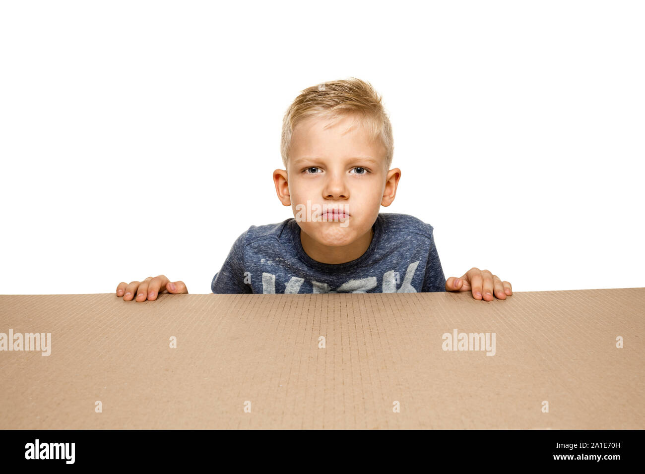 Cute and upset little boy opening the biggest postal package ...