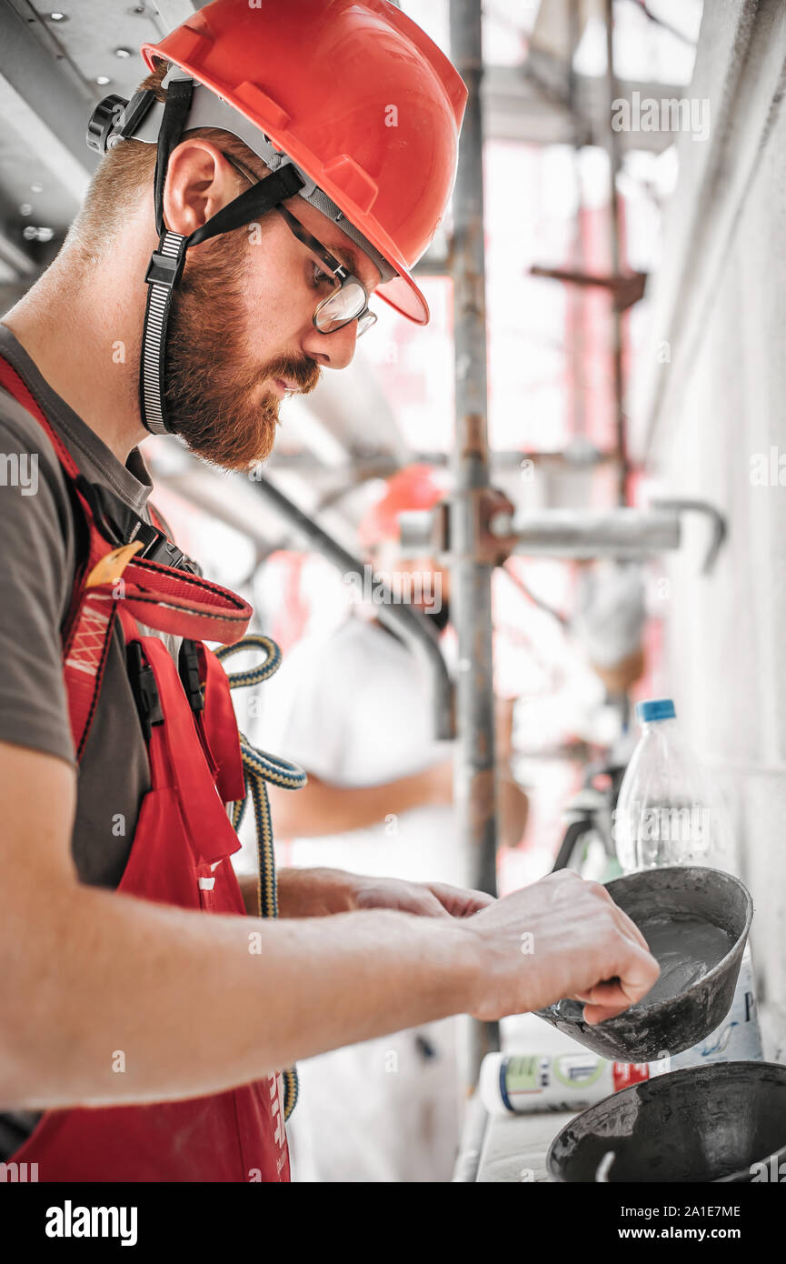 Construction mason worker plastering old building wall using cement ...