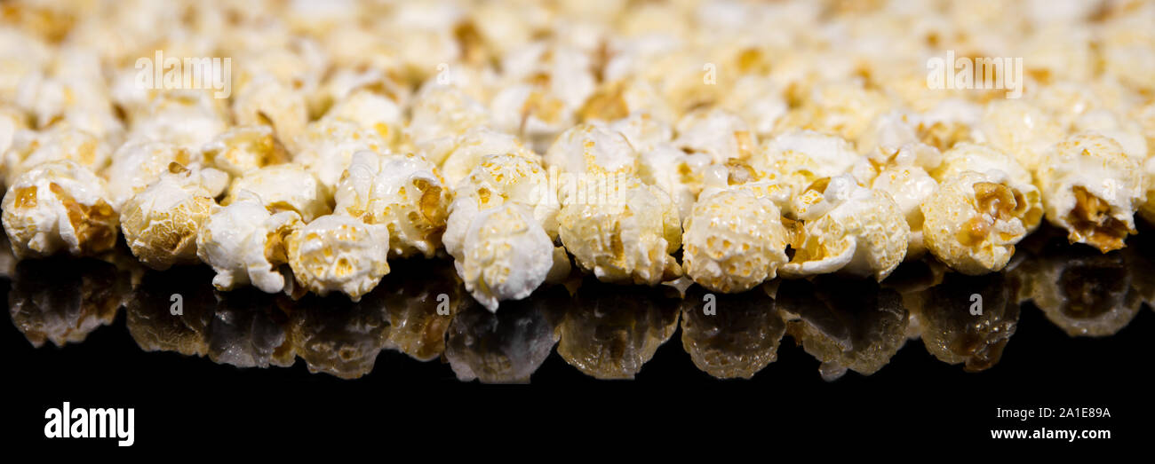 banner or header with sweet popcorn, black underground with reflections ...