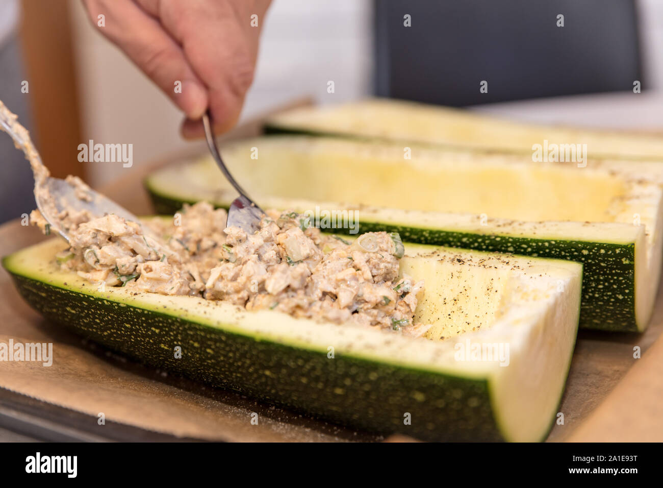 Man is stuffing three giant courgette or zucchini, healthy nutrition ...
