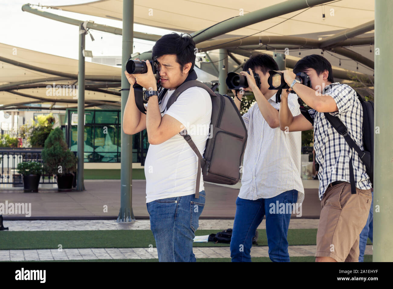 Male tourists taking pictures with a camera while traveling. Trips are ...