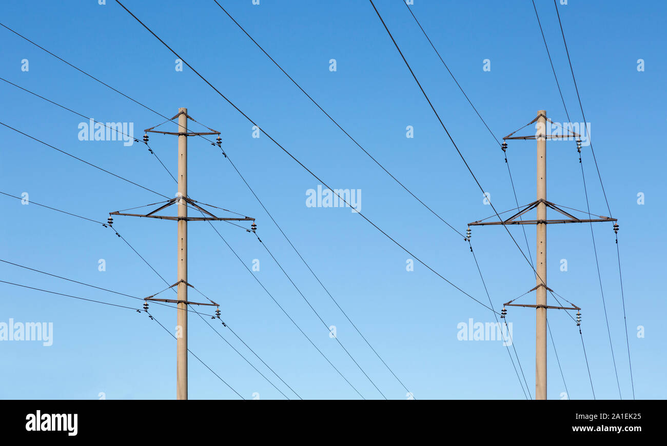 Two concrete pylons of a high voltage power line with steel cross-arms ...
