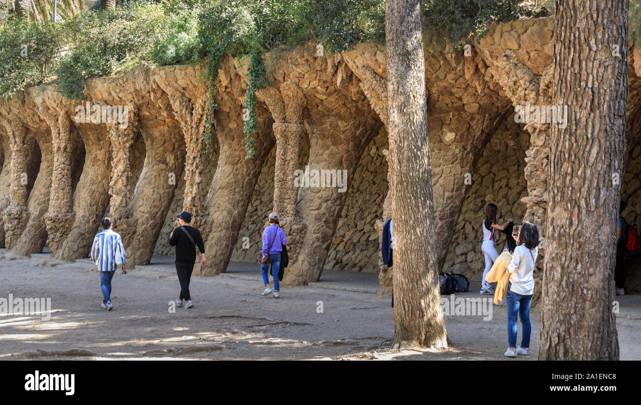 People walk through the colonnade of organic stone columns in Park ...