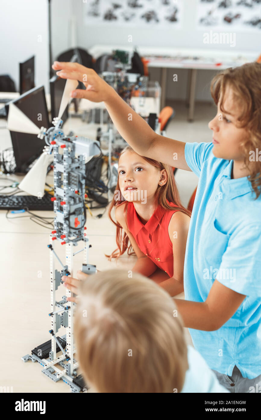 Children having robotics class making tower electronic fan looking at ...