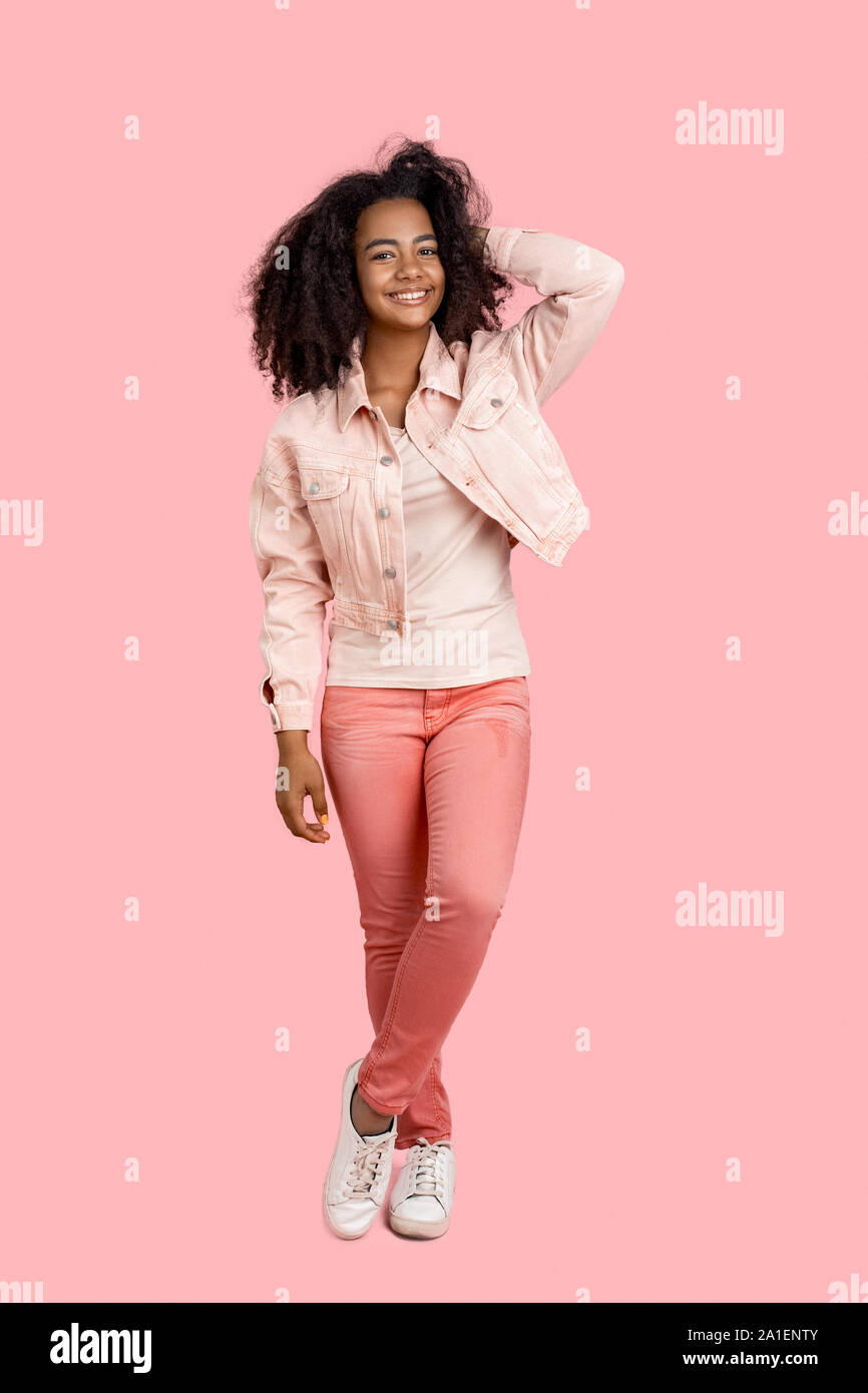 African descent girl wearing denim jacket standing isolated on pink ...