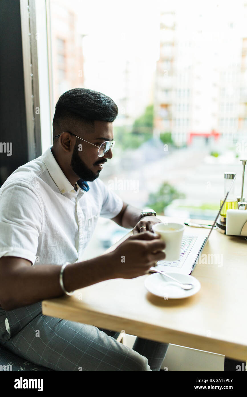 Man using laptop computer while drinking a cup hot milk tea, outdoor ...