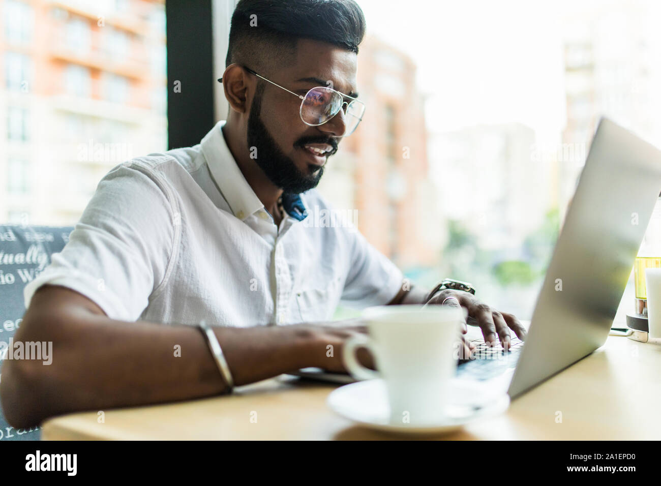 Man using laptop computer while drinking a cup hot milk tea, outdoor ...