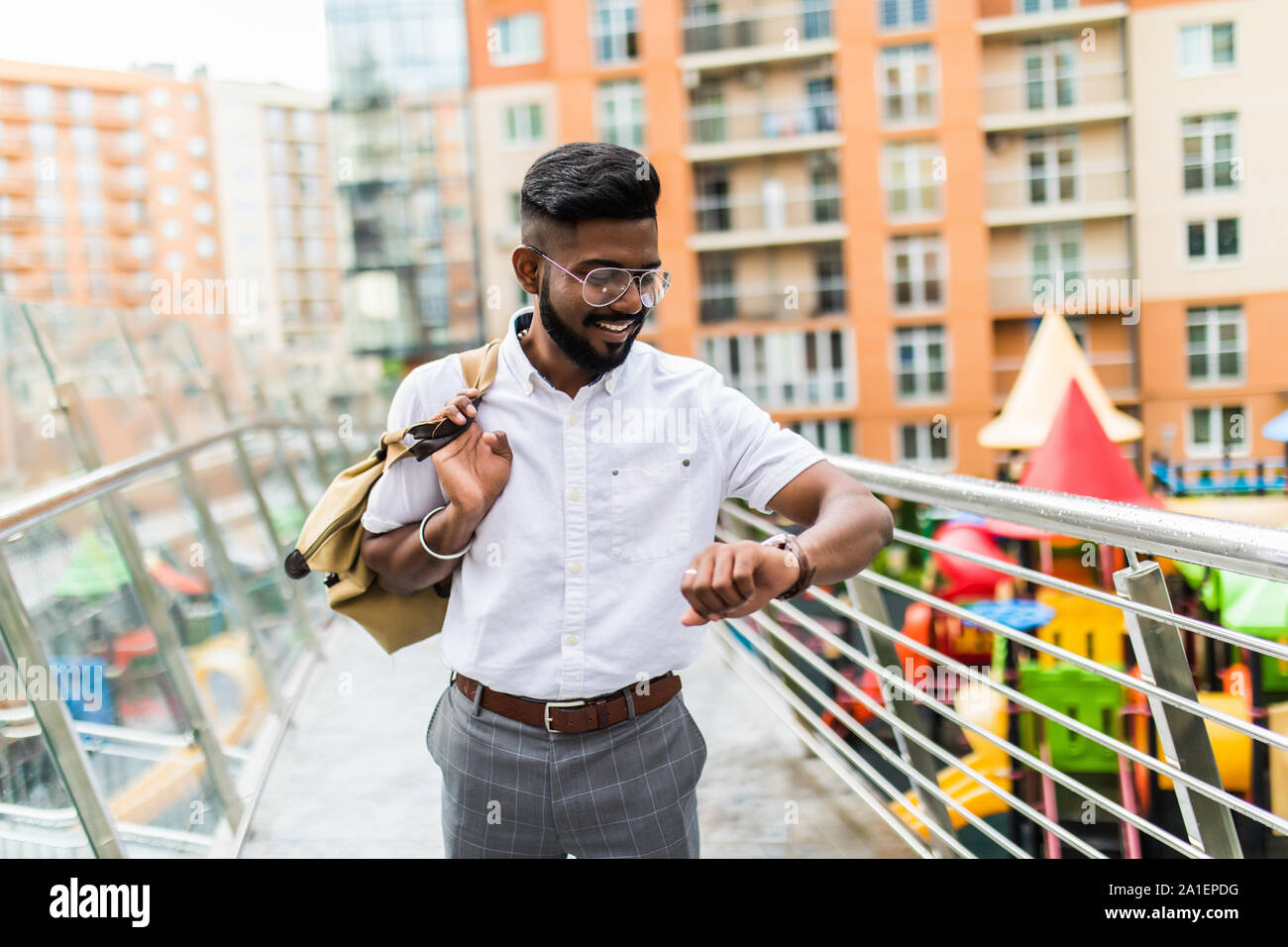 Indian man with bag on the street look at watch in a hurry Stock Photo ...