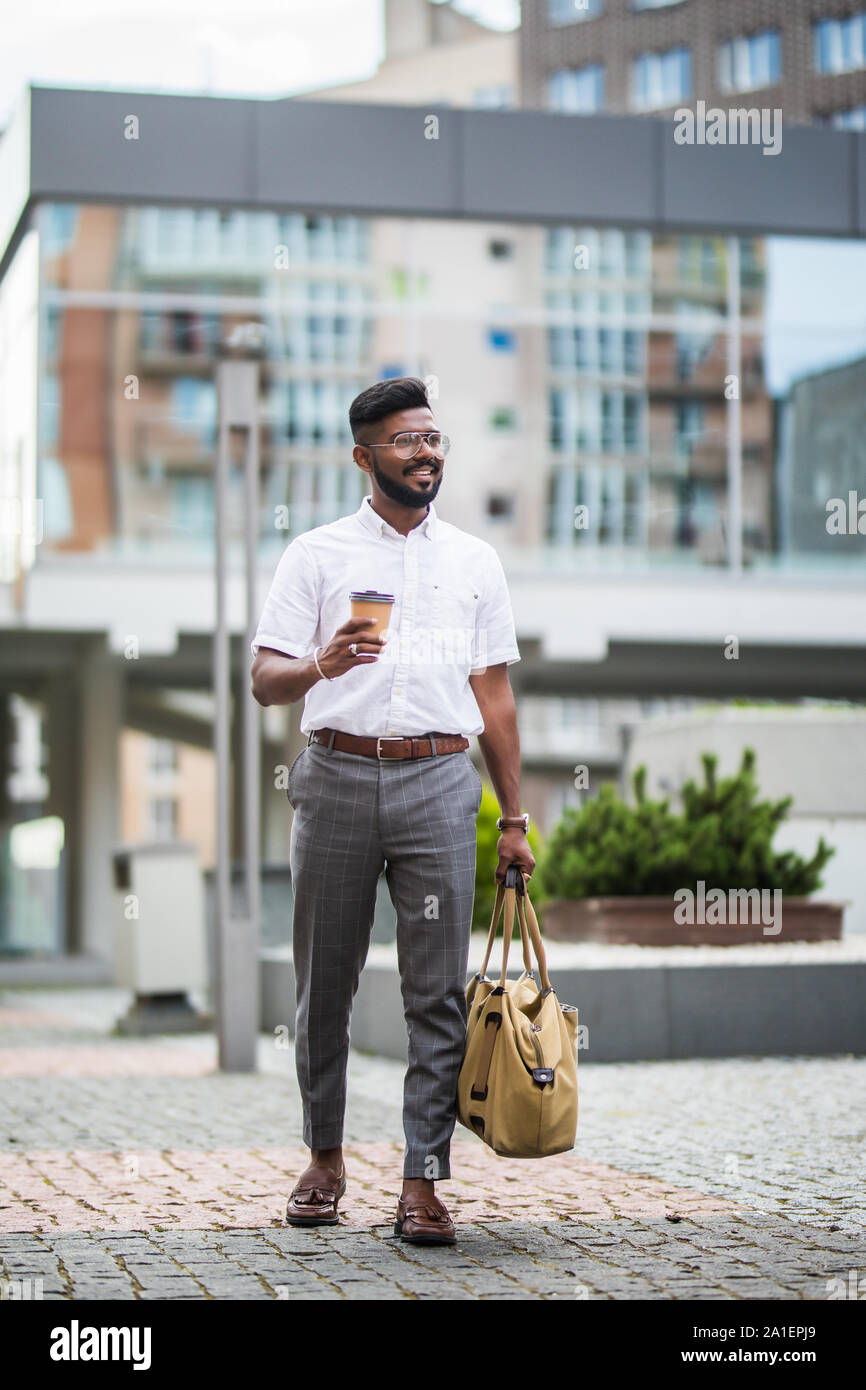 Young indian man walking on the street and drink coffee Stock Photo - Alamy