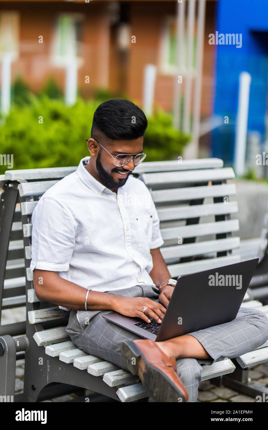 Young indian men sitting bench hi-res stock photography and images - Alamy
