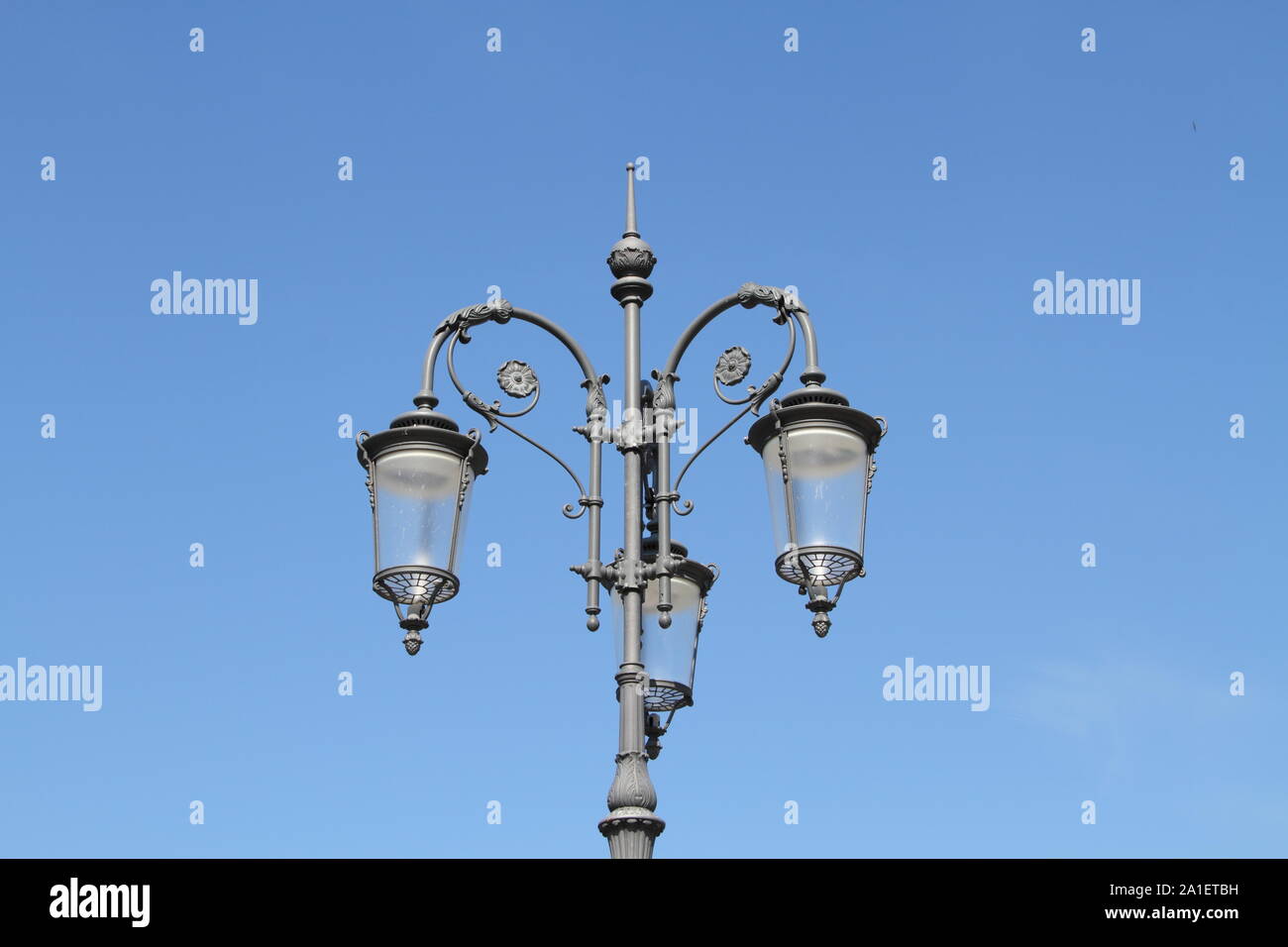 a beautiful old three-lamp street lamp Stock Photo - Alamy