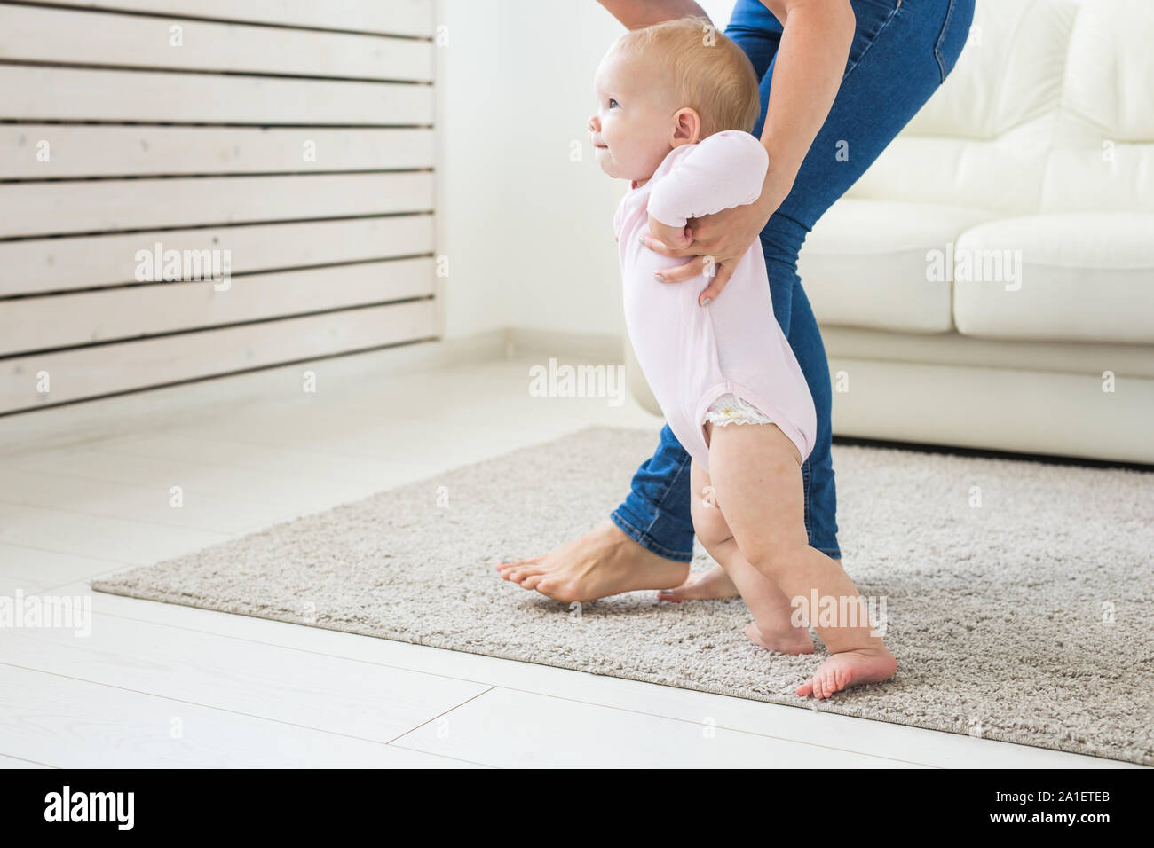 First steps. Little baby girl learning to walk. Studio shoot on white ...