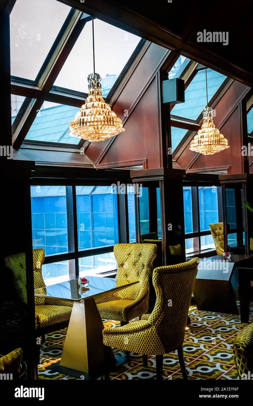 Tables and lounge chairs with hanging lights in a comfortable lounge ...