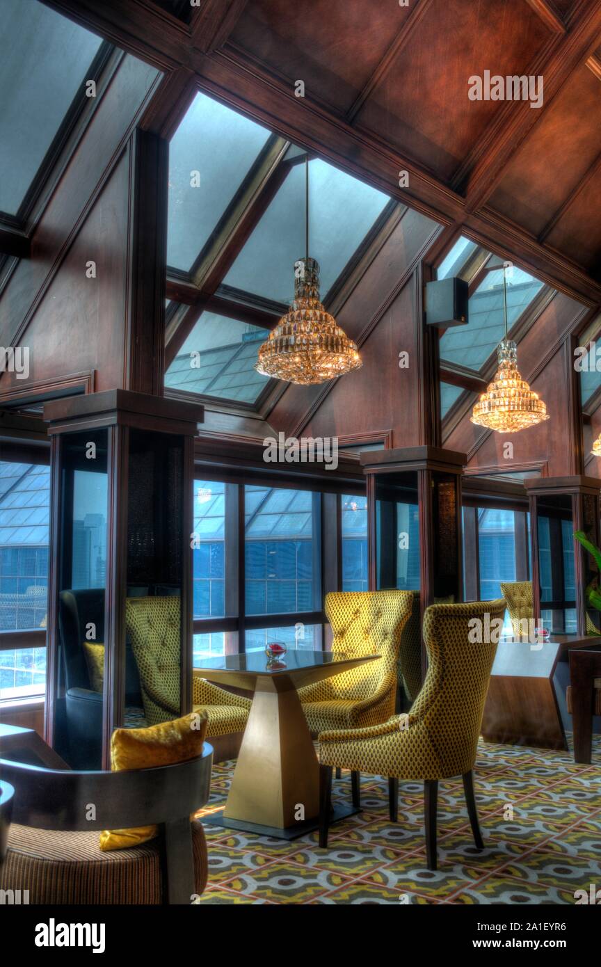 Tables and lounge chairs with hanging lights in a comfortable lounge ...