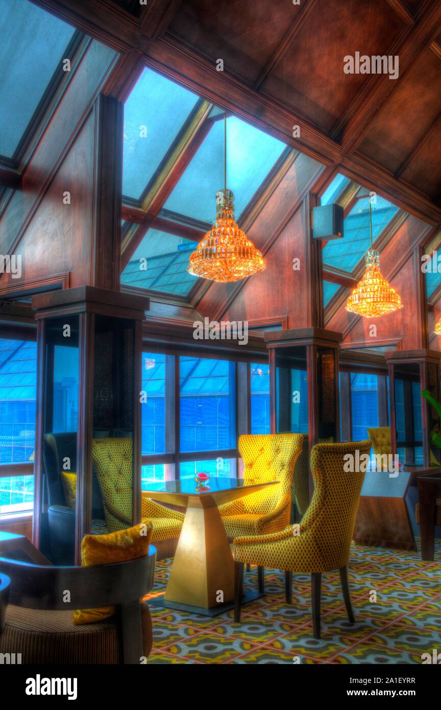 Tables and lounge chairs with hanging lights in a comfortable lounge ...