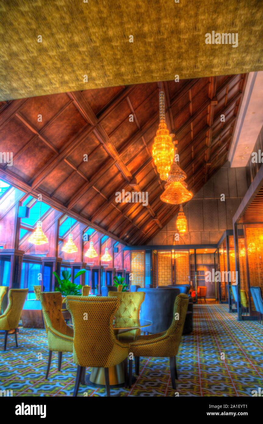 Tables and lounge chairs with hanging lights in a comfortable lounge ...