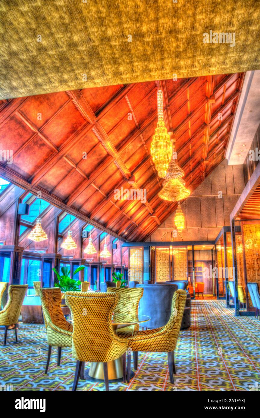 Tables and lounge chairs with hanging lights in a comfortable lounge ...