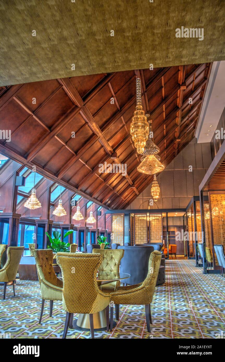 Tables and lounge chairs with hanging lights in a comfortable lounge ...