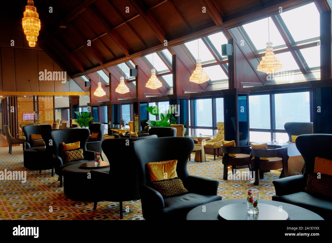 Tables and lounge chairs with hanging lights in a comfortable lounge ...