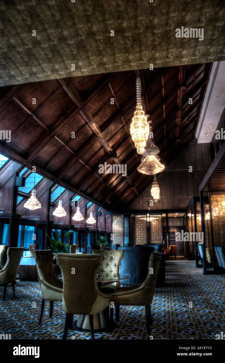 Tables and lounge chairs with hanging lights in a comfortable lounge ...