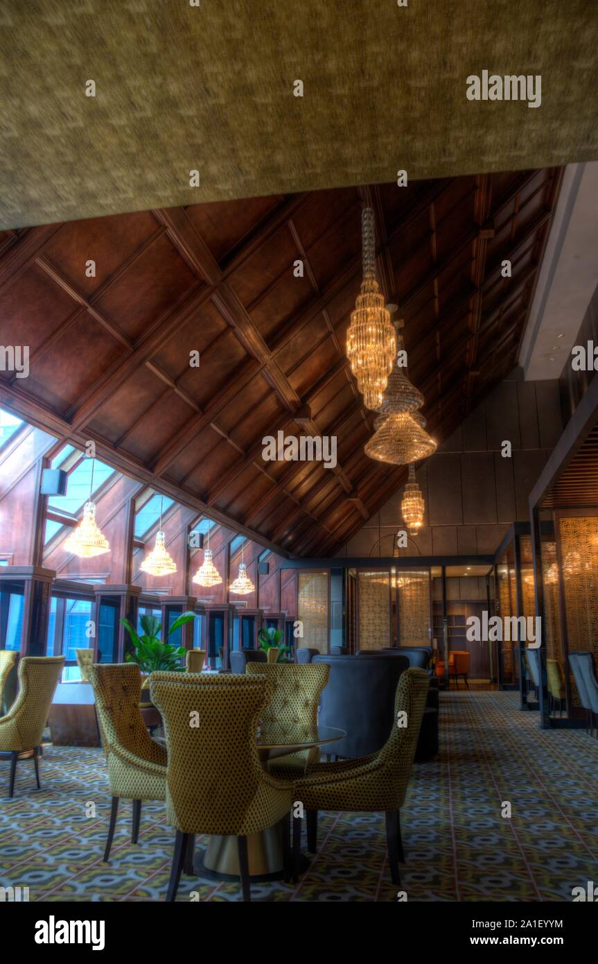 Tables and lounge chairs with hanging lights in a comfortable lounge ...