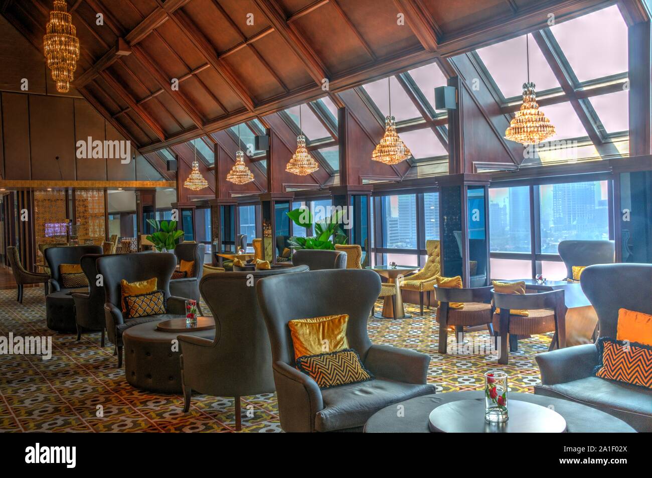 Tables and lounge chairs with hanging lights in a comfortable lounge ...