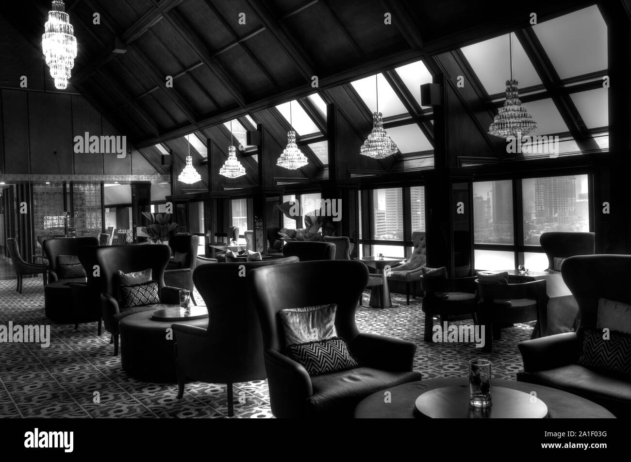 Tables and lounge chairs with hanging lights in a comfortable lounge ...