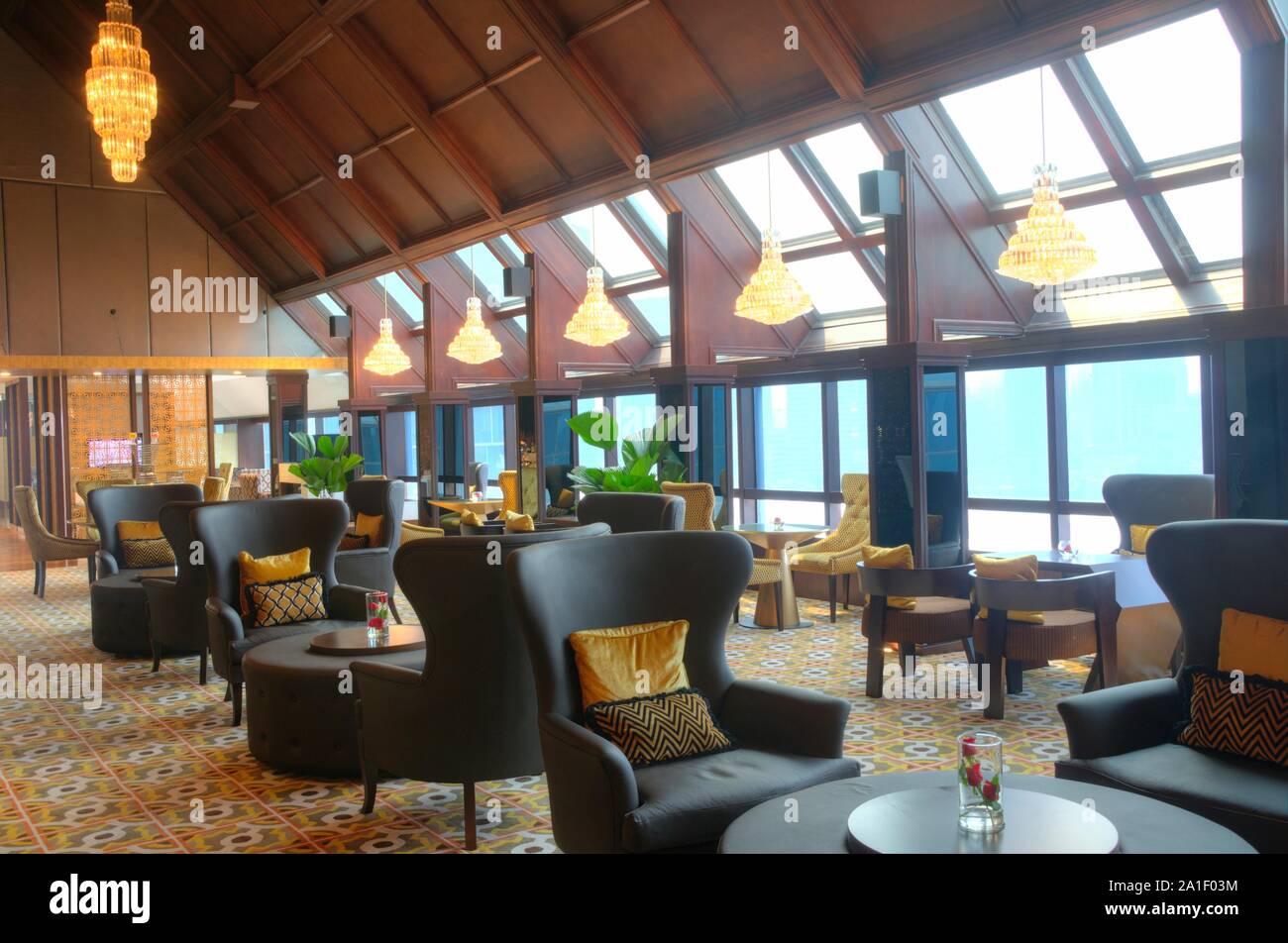 Tables and lounge chairs with hanging lights in a comfortable lounge ...