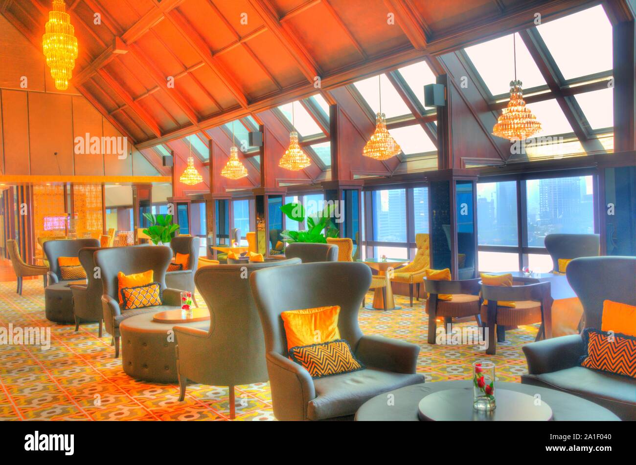 Tables and lounge chairs with hanging lights in a comfortable lounge ...