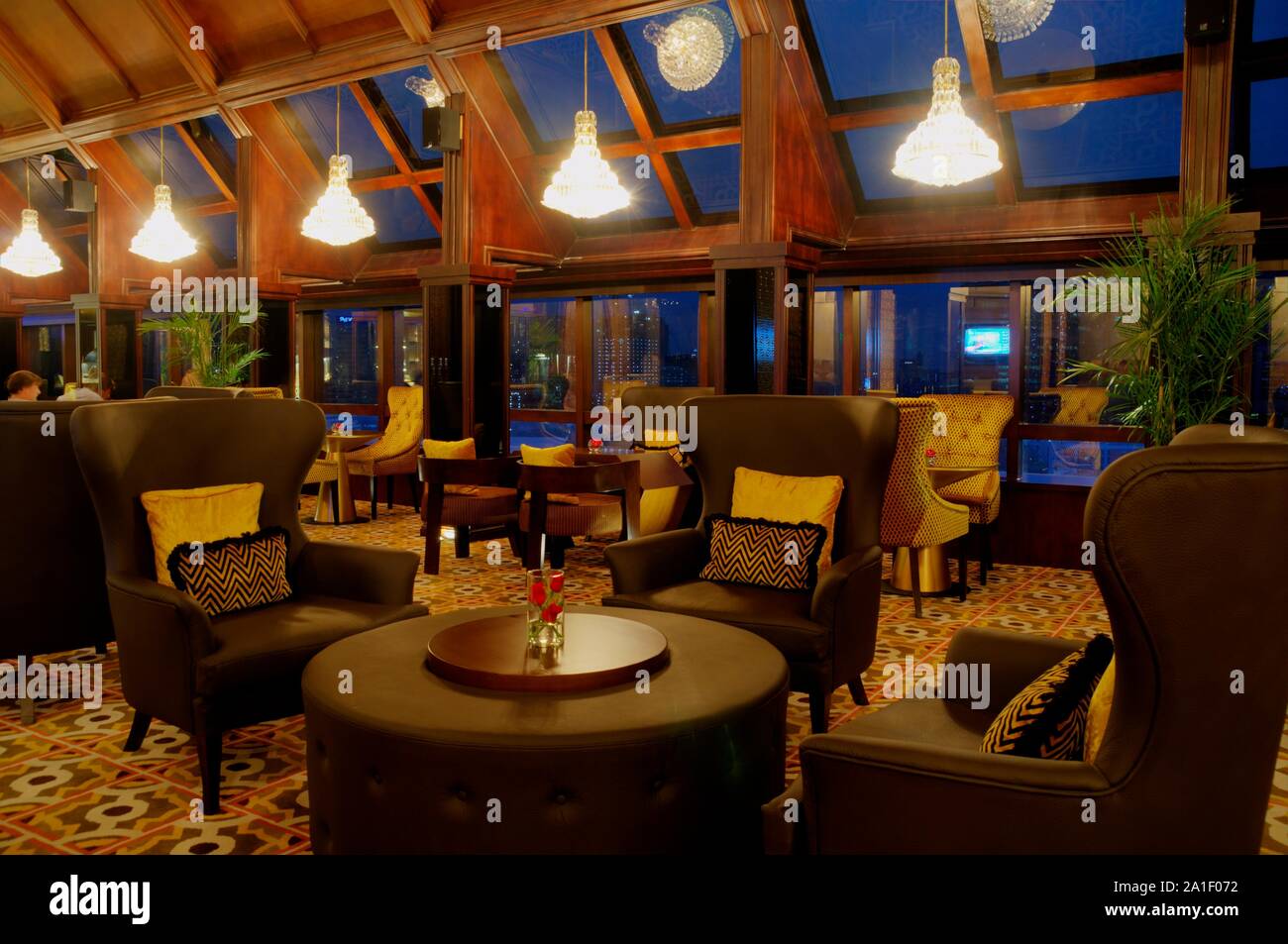 Tables and lounge chairs with hanging lights in a comfortable lounge ...