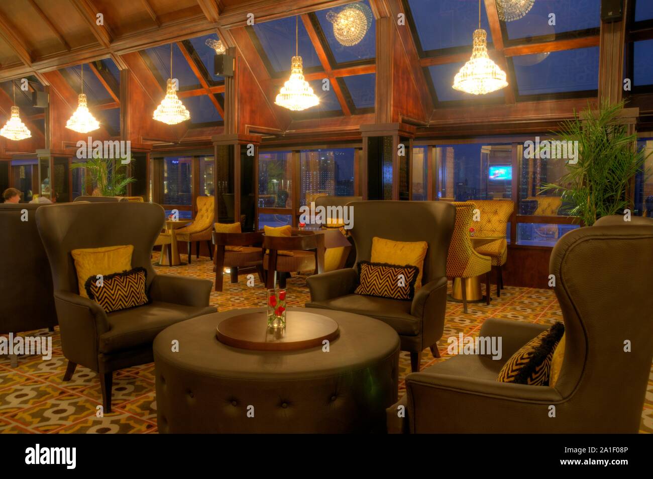 Tables and lounge chairs with hanging lights in a comfortable lounge ...