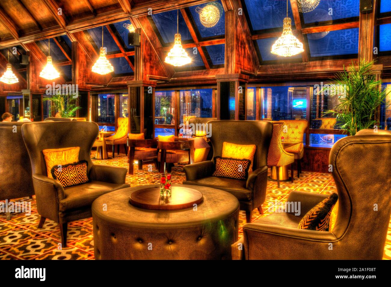 Tables and lounge chairs with hanging lights in a comfortable lounge ...