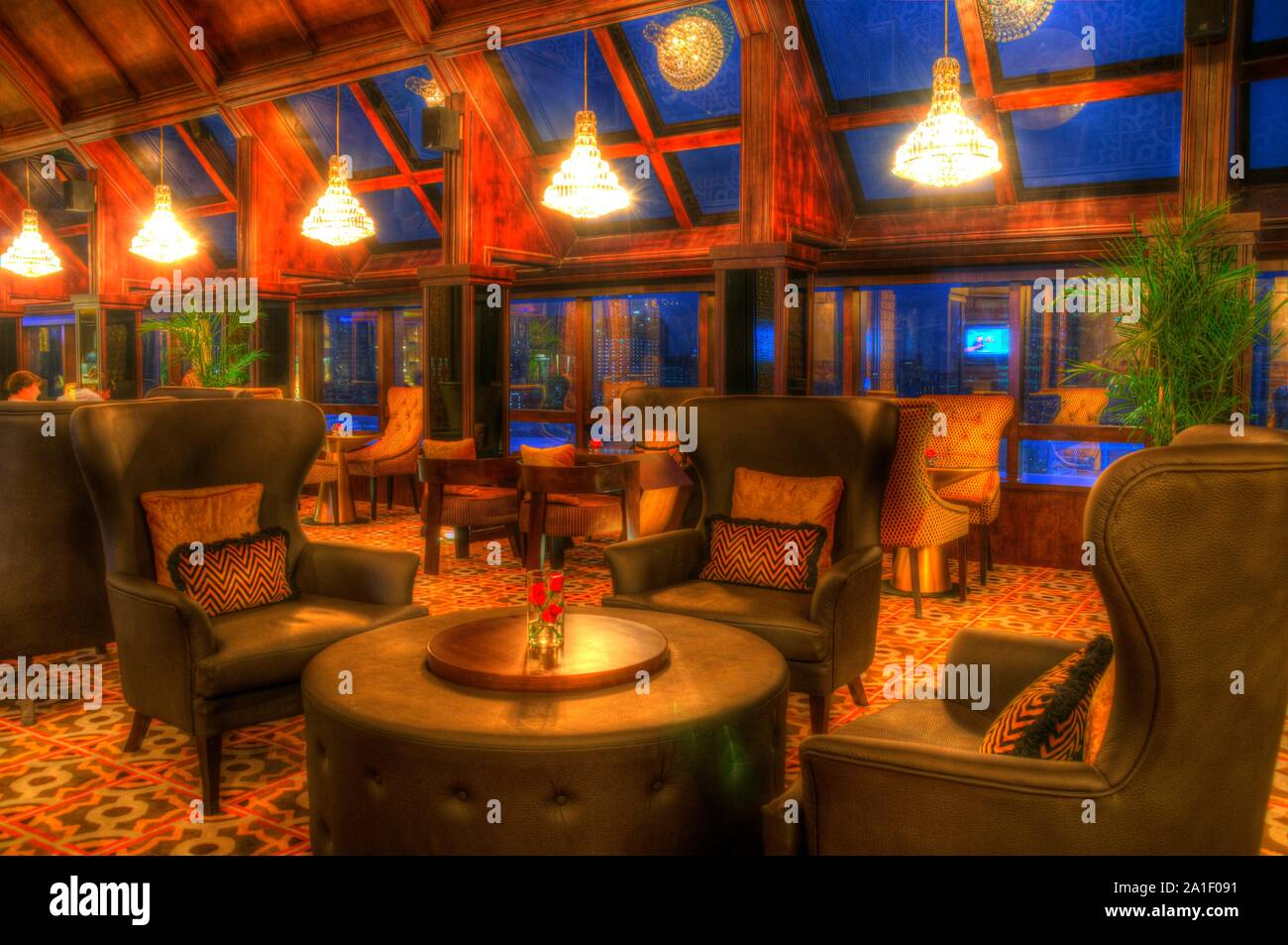 Tables and lounge chairs with hanging lights in a comfortable lounge ...