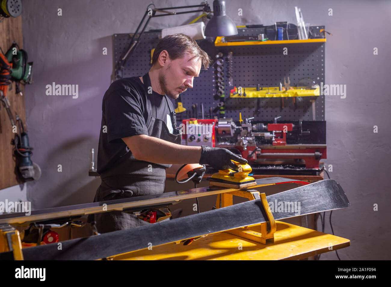 Repair, people concept - mechanic, man is rubbing a ski Stock Photo - Alamy