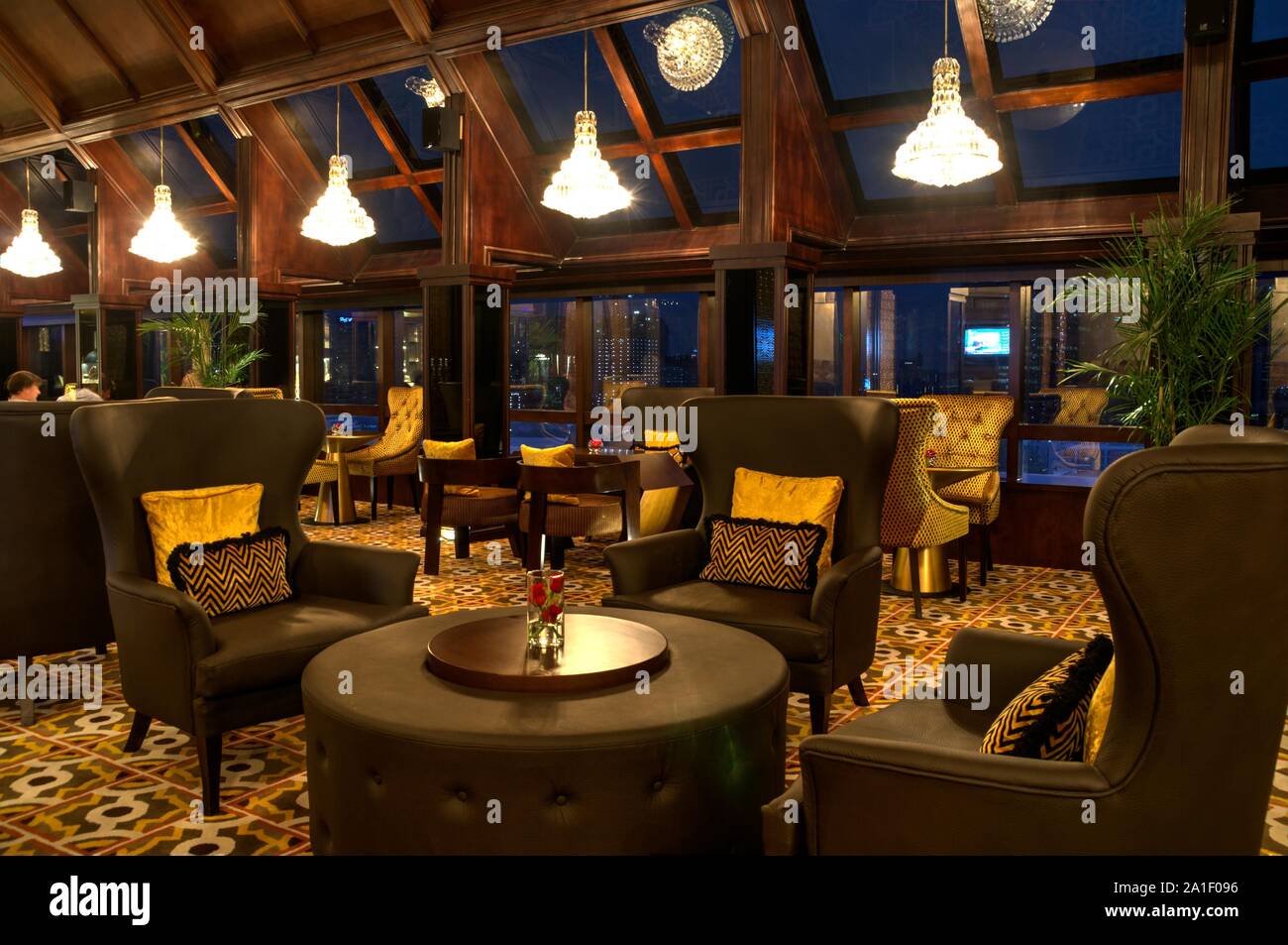 Tables and lounge chairs with hanging lights in a comfortable lounge ...