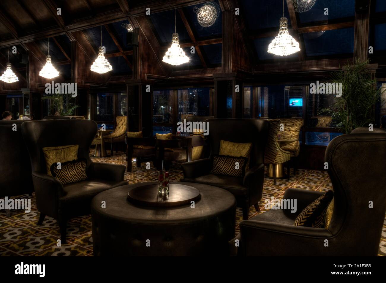 Tables and lounge chairs with hanging lights in a comfortable lounge ...