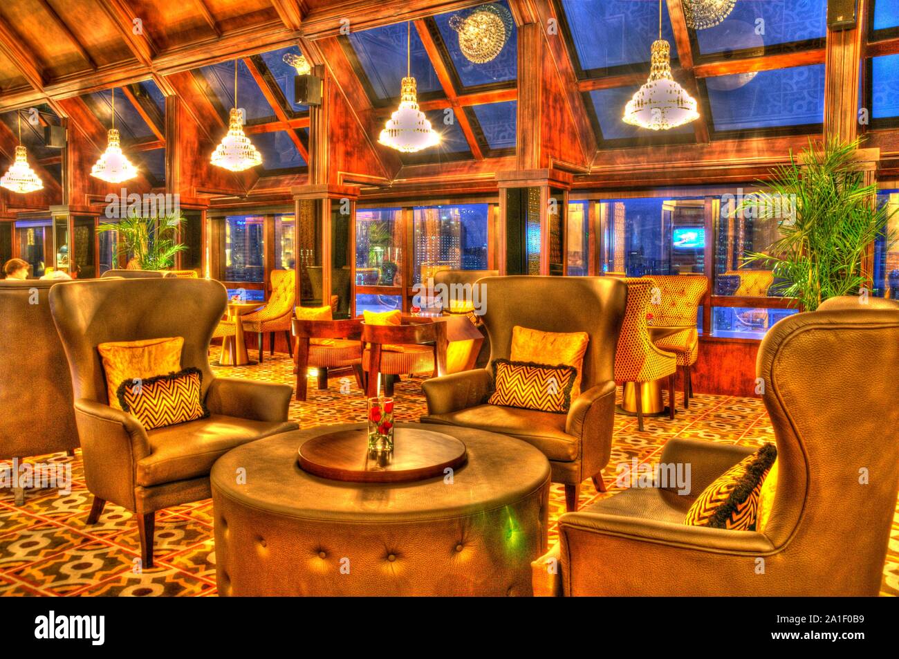 Tables and lounge chairs with hanging lights in a comfortable lounge ...