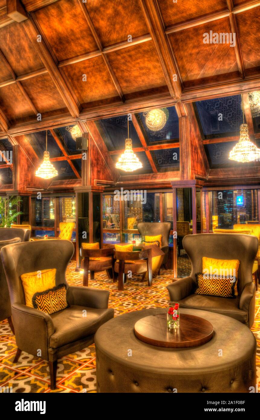 Tables and lounge chairs with hanging lights in a comfortable lounge ...