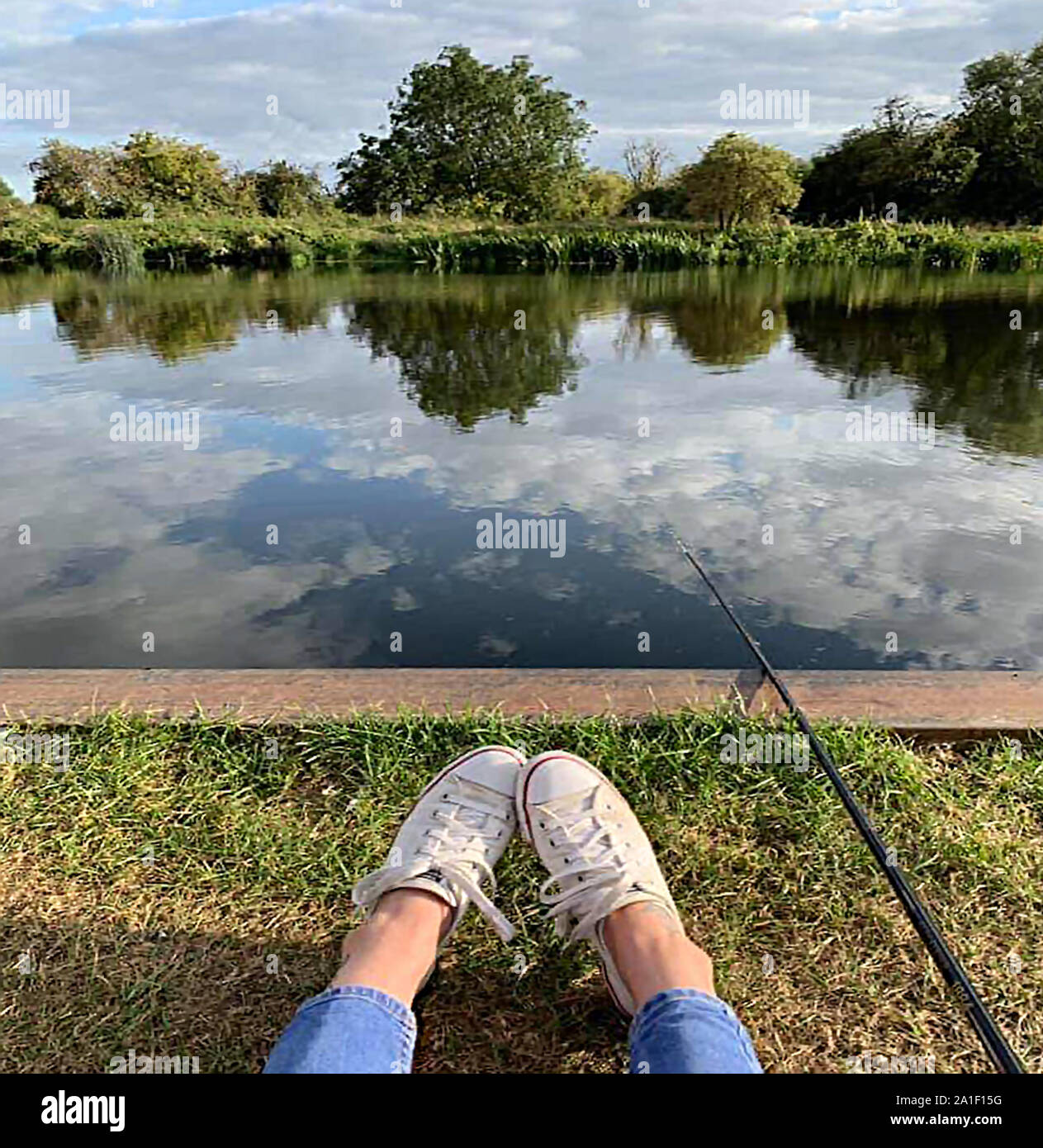 Young ladies crossed feet by lake Stock Photo - Alamy