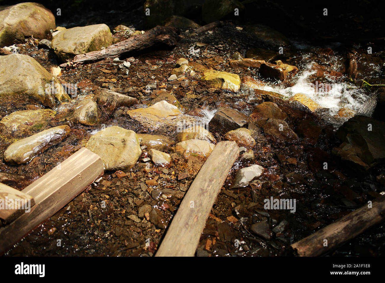 flowing mountain stream with transparent water and stones on bottom ...