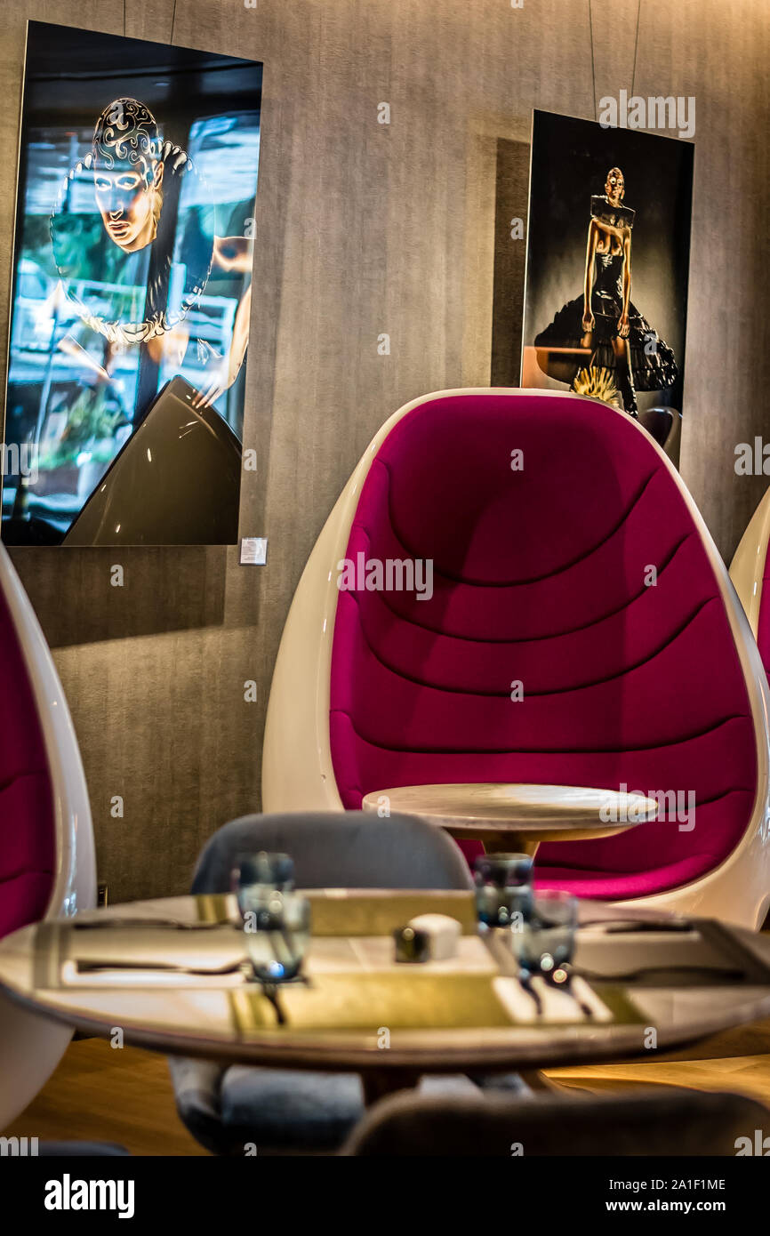 purple and white space capsule seating in a chic grey cafe Stock Photo ...