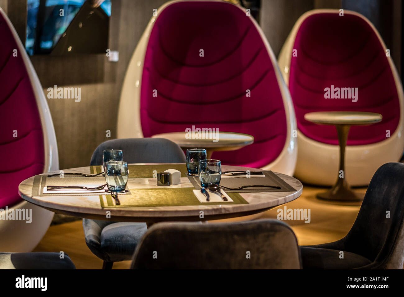 purple and white space capsule seating in a chic grey cafe Stock Photo ...