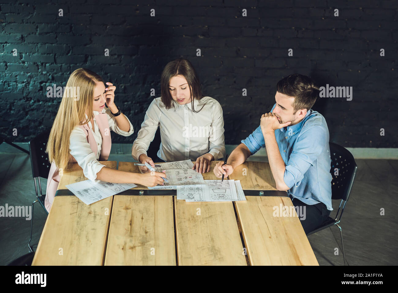 Young team of coworkers watching storyboard for shooting video in ...
