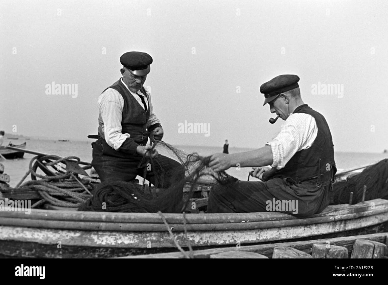 Fischer sortieren ihre Netze bevor sie sie zum Fischfang ins Meer ...